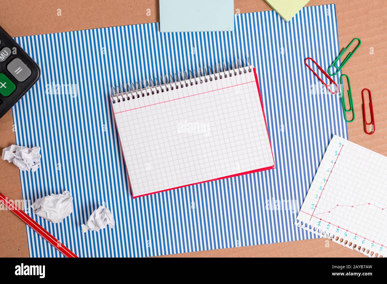 Cardboard desk with a striped blue sheet, notebook paper and office ...