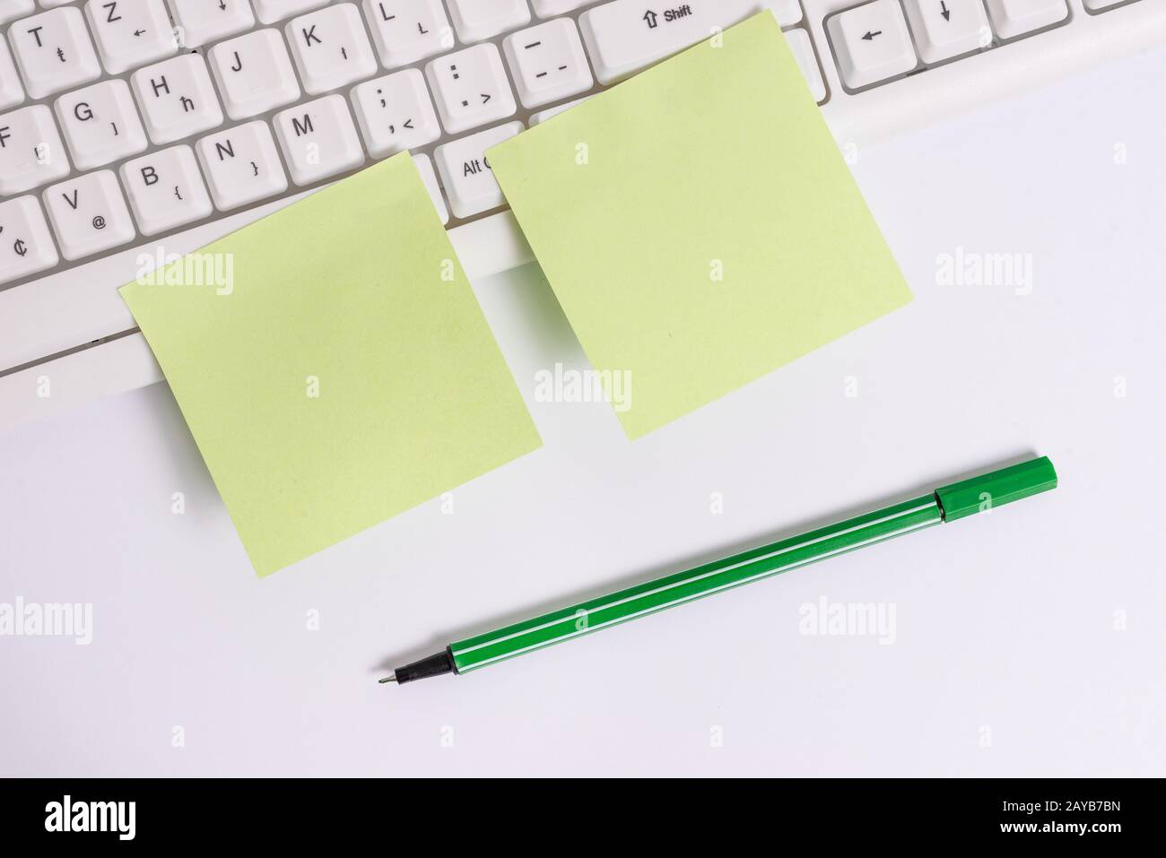 Square empty green note paper with pencil on the white background and ...