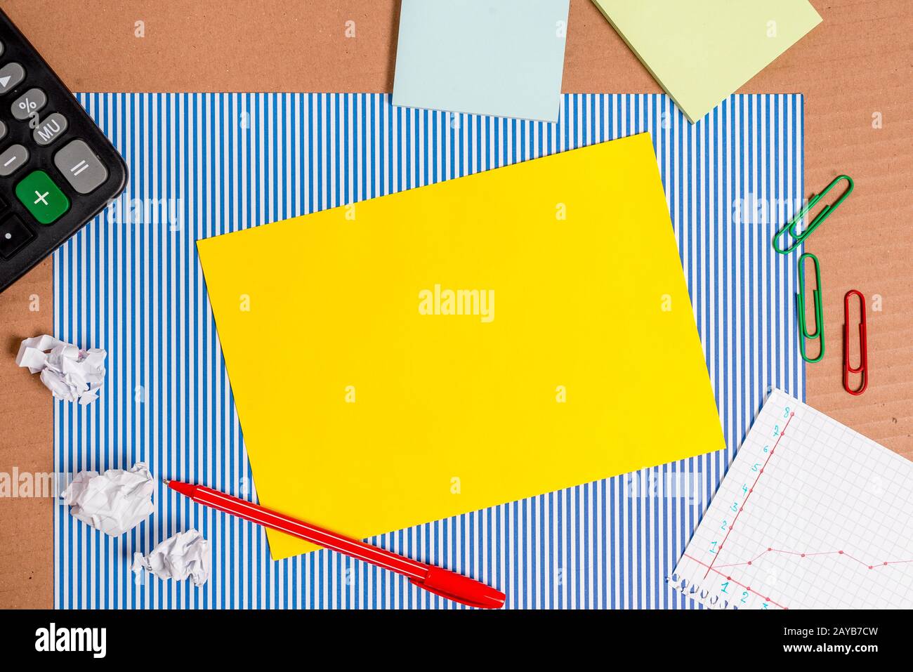 Cardboard desk with a striped blue sheet, notebook paper and office ...