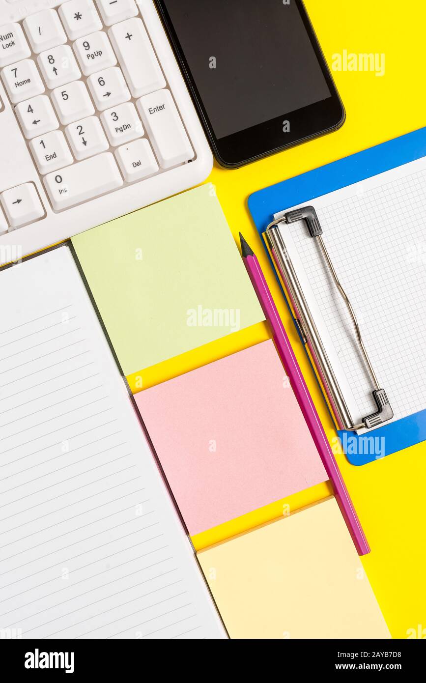Flat lay above orange table with blank colored papers for text messages ...