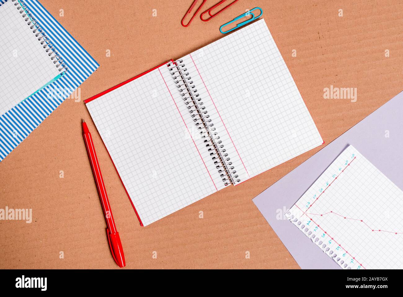 Cardboard desk with a striped blue sheet, notebook paper and office ...