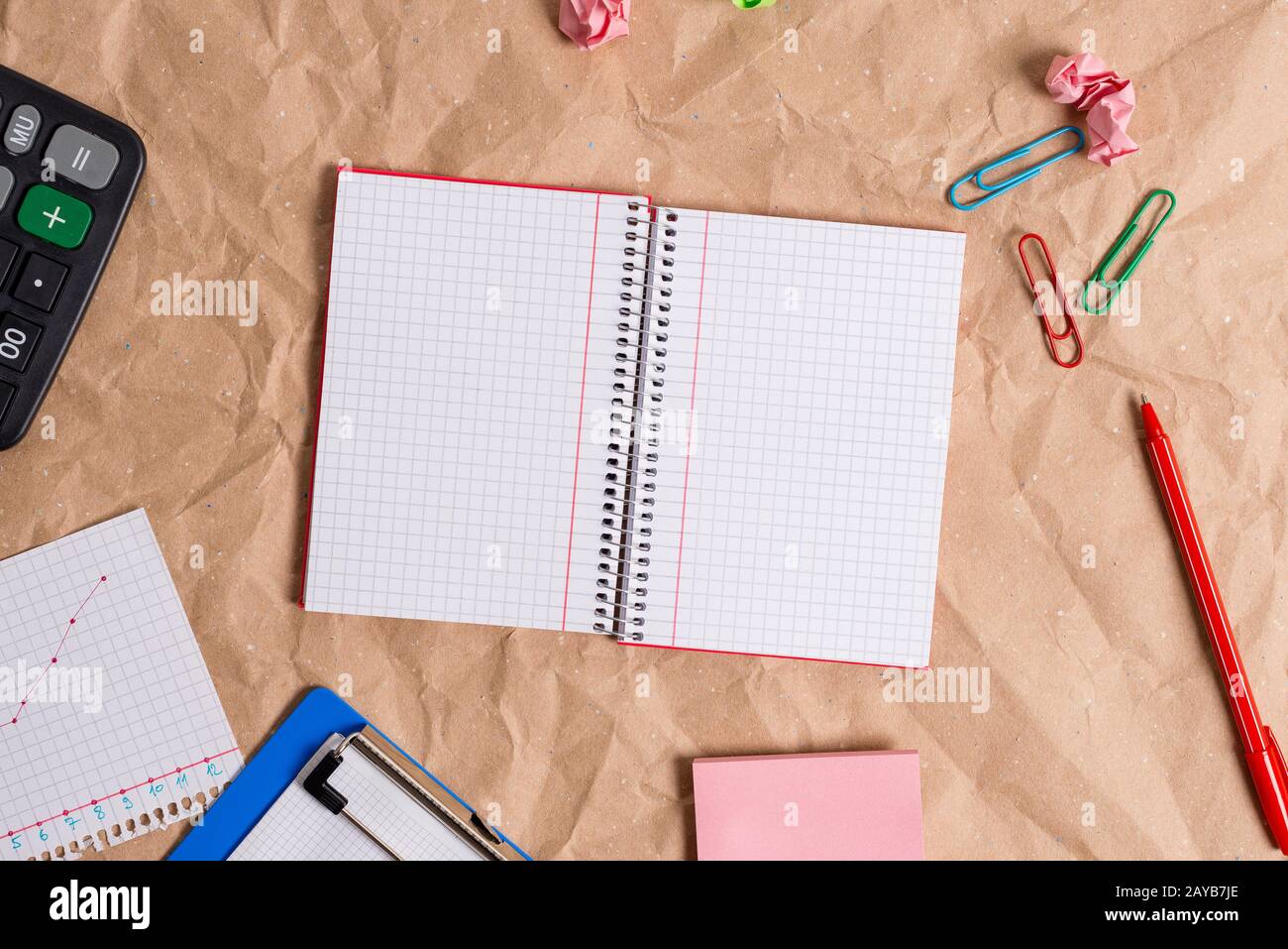 Desk made of crumpled craft paper with an open square paper spiral red ...