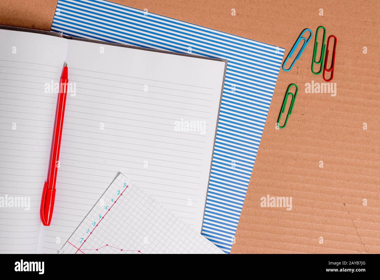 Cardboard desk with a striped blue sheet, notebook paper and office ...