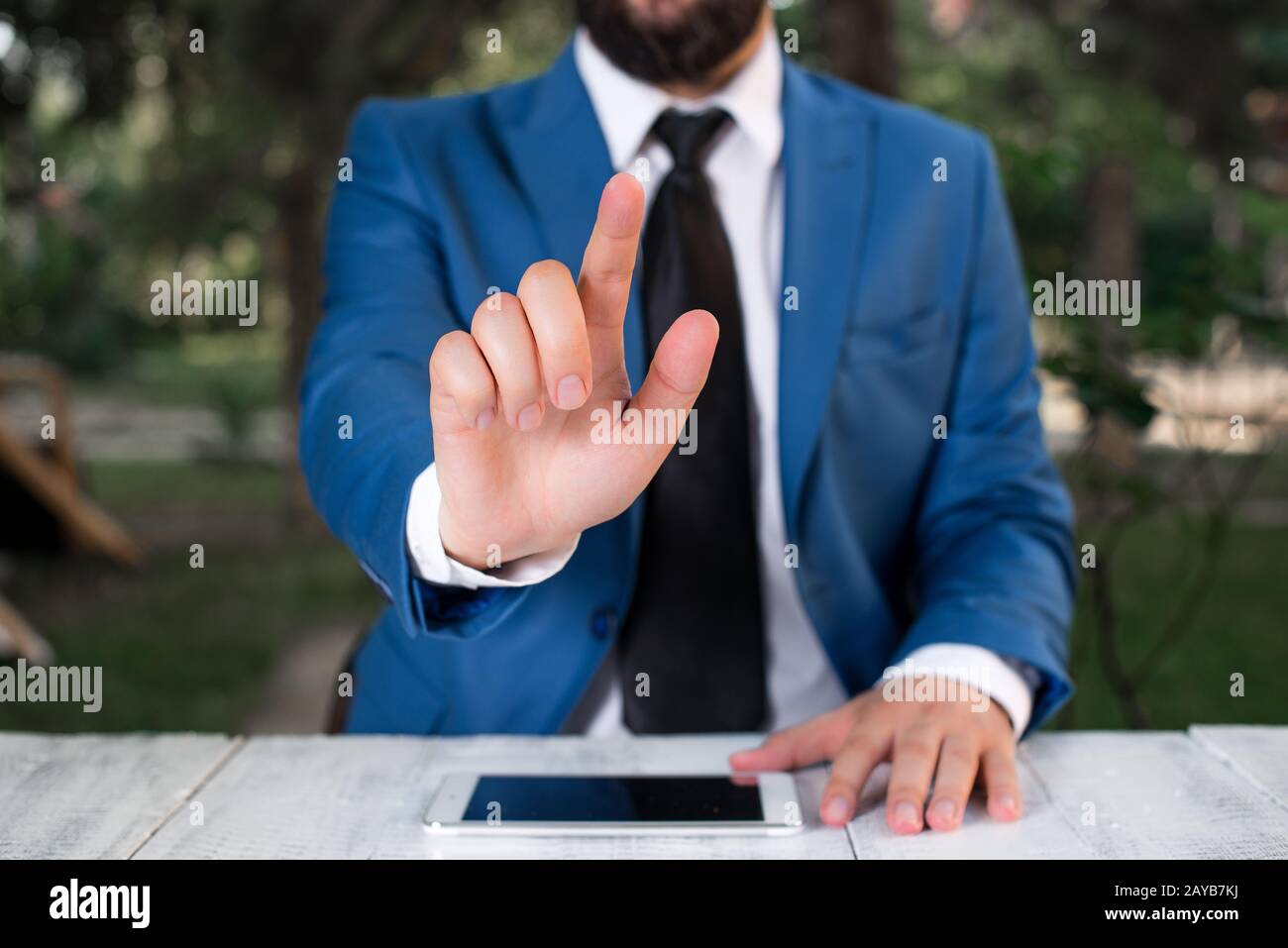Businessman with pointing finger in front of him. Businessman holds lap ...