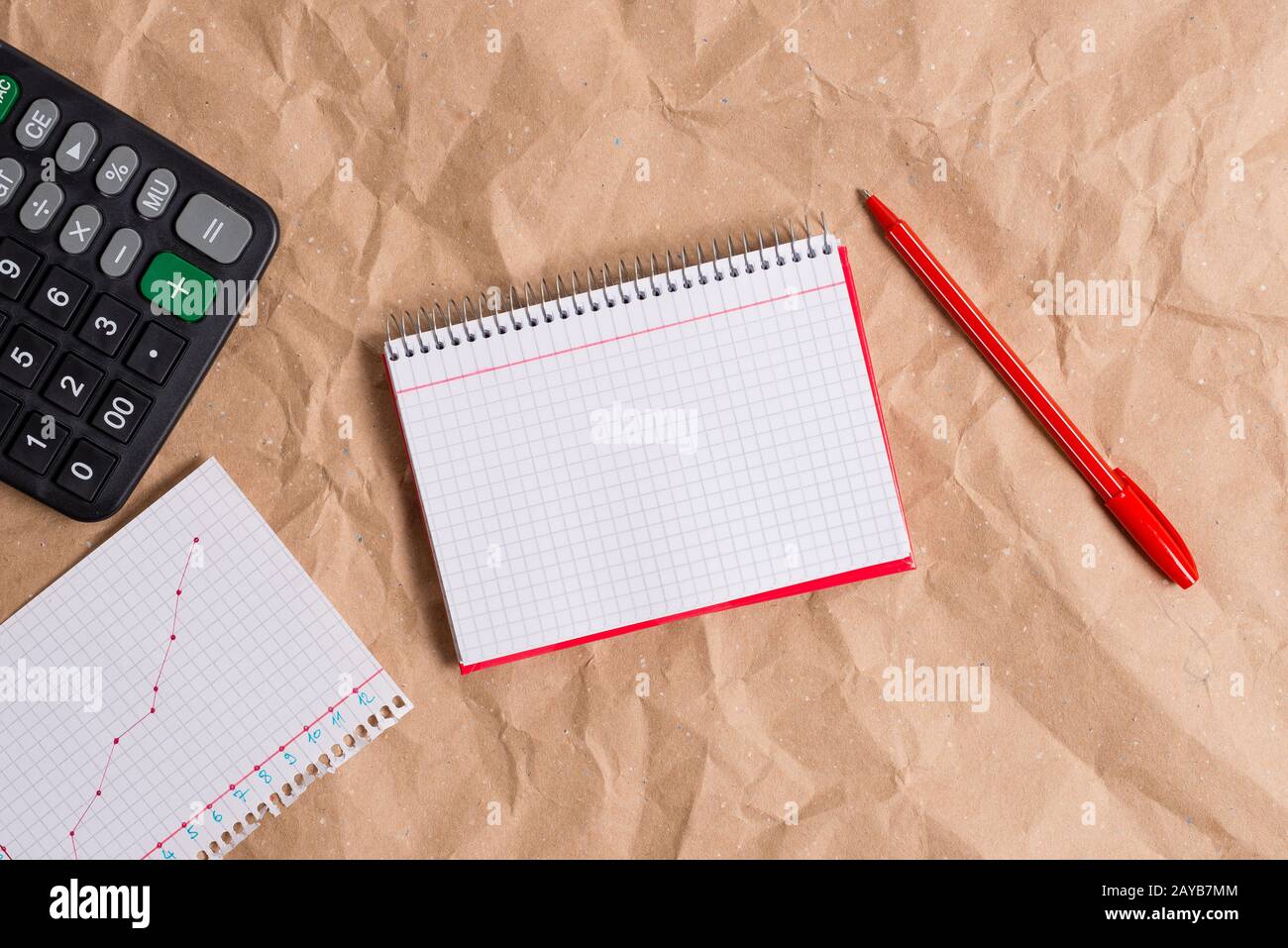 Desk made of crumpled craft paper with an open square paper spiral red ...
