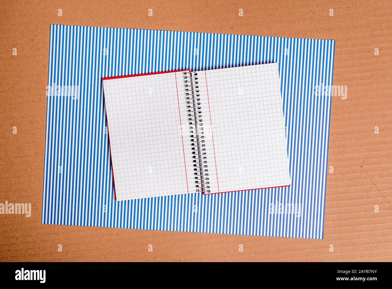 Cardboard desk with a striped blue sheet, notebook paper and office ...