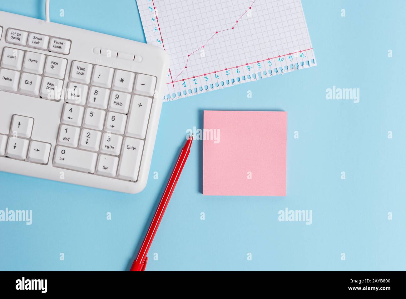 Light blue desk with empty paper notes, computer keyboard and office ...
