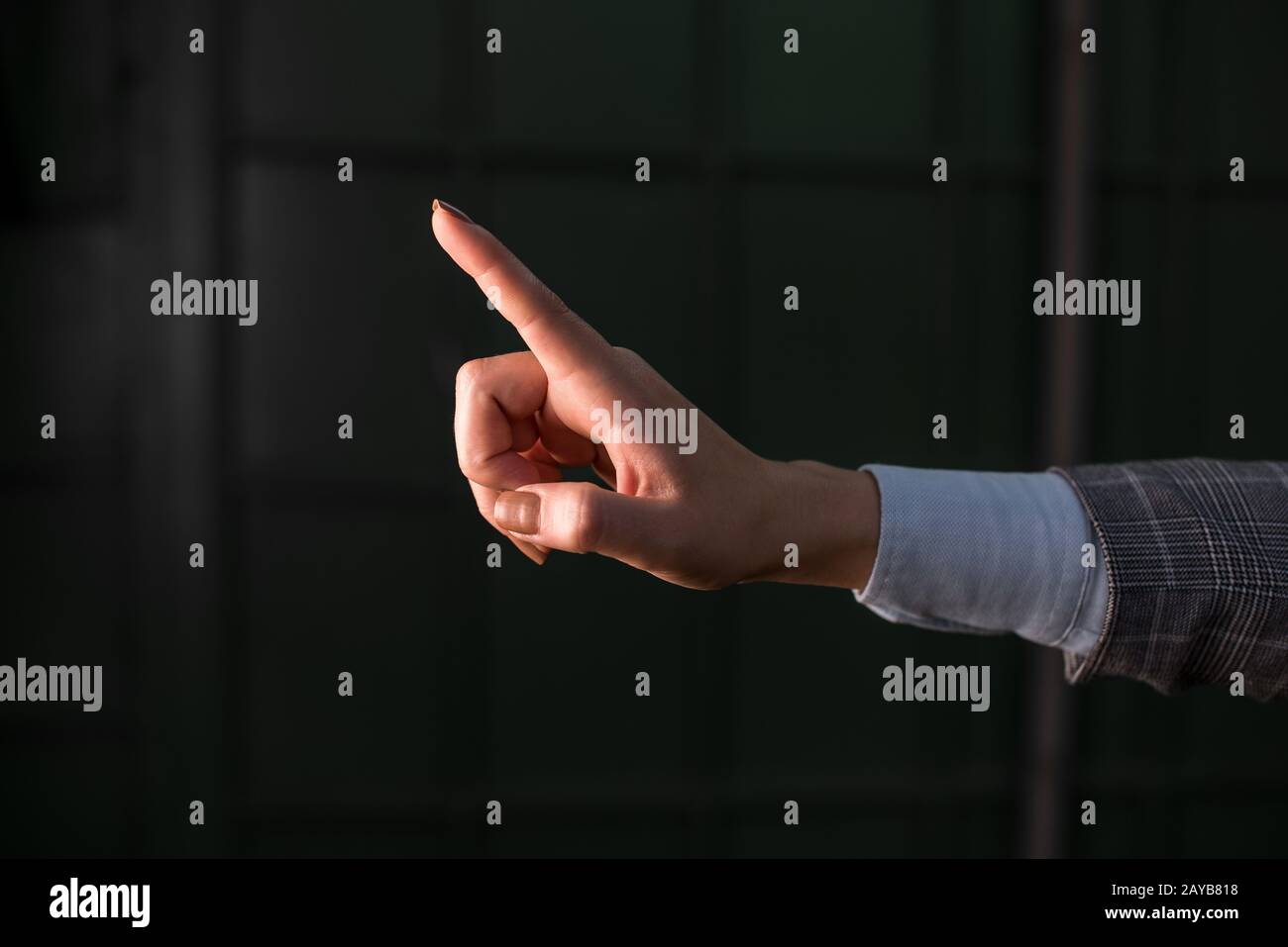 Finger pointing in the empty space. Dark background with hand pointing ...
