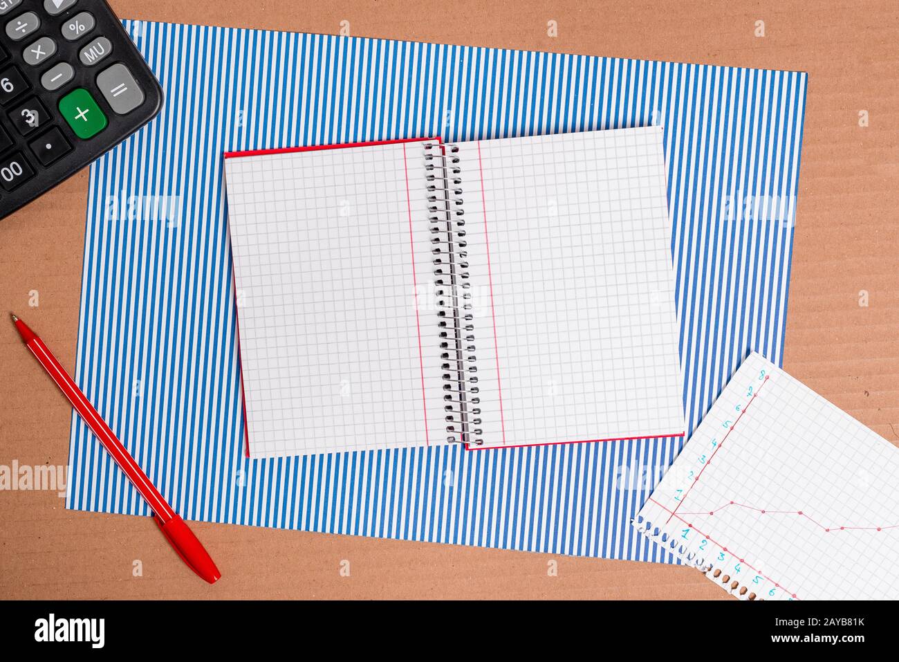 Cardboard desk with a striped blue sheet, notebook paper and office ...