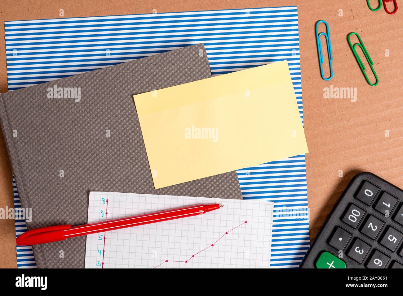 Cardboard desk with a striped blue sheet, notebook paper and office ...