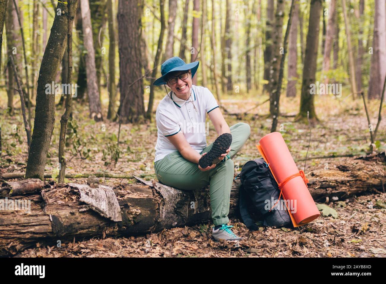 Young woman having trouble feeling knee pain during travel in forest ...