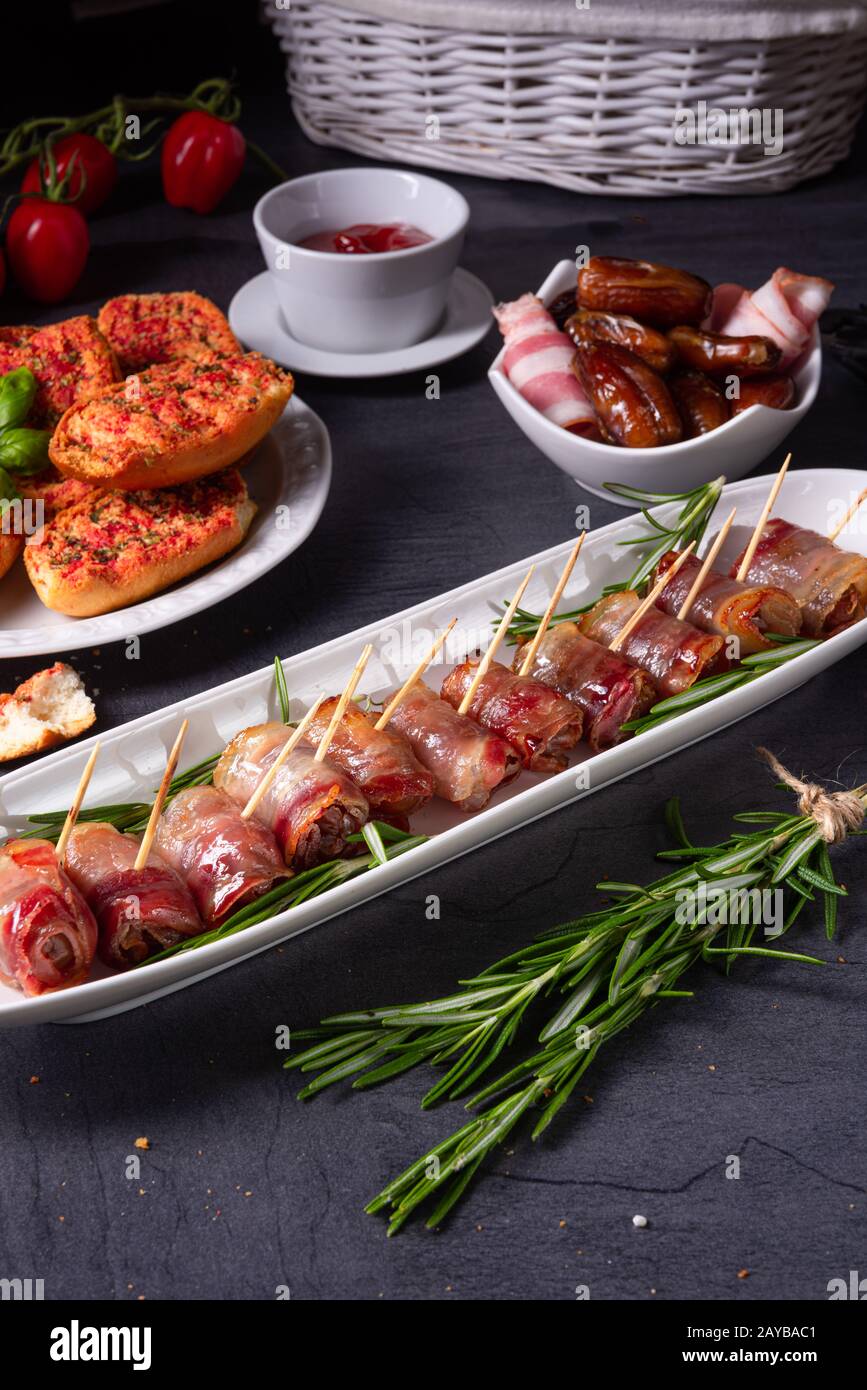 dates wrapped in bacon and delicious tapas Stock Photo - Alamy