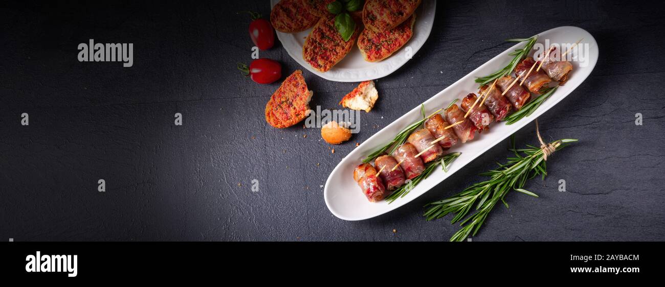 dates wrapped in bacon and delicious tapas Stock Photo - Alamy