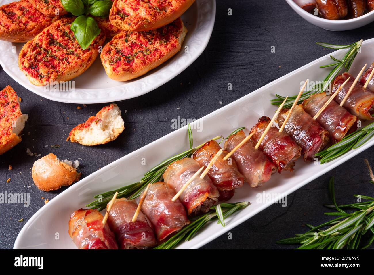 dates wrapped in bacon and delicious tapas Stock Photo - Alamy