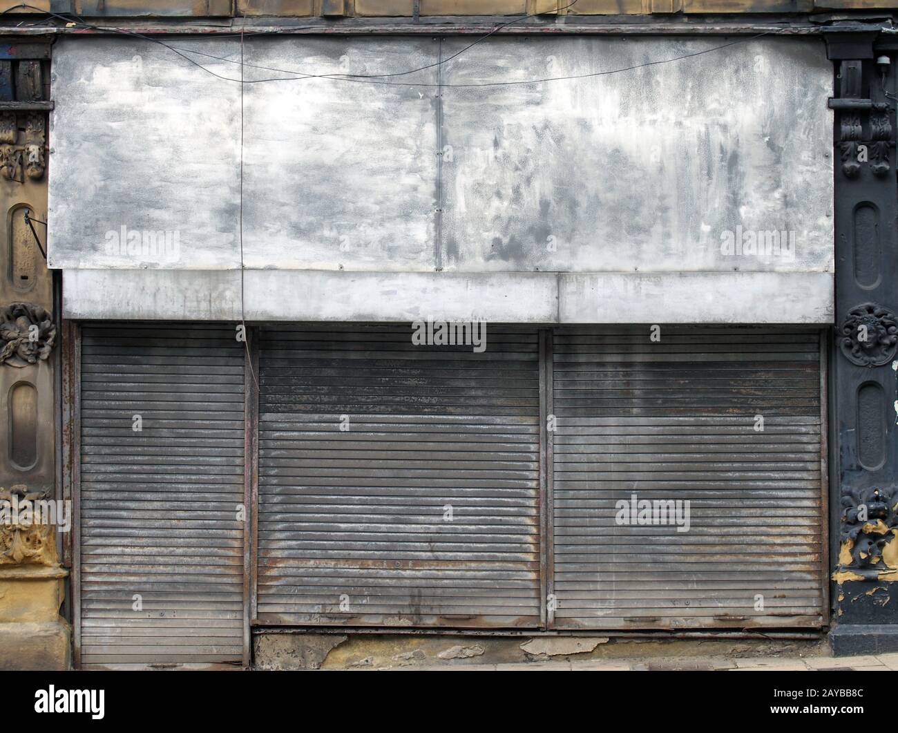 the front of an abandoned store on a street with closed dirty rusting ...