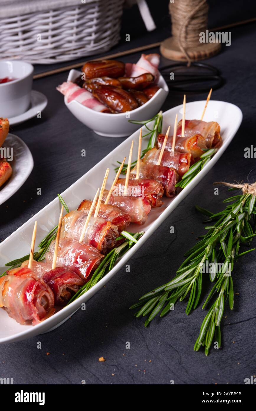 dates wrapped in bacon and delicious tapas Stock Photo - Alamy