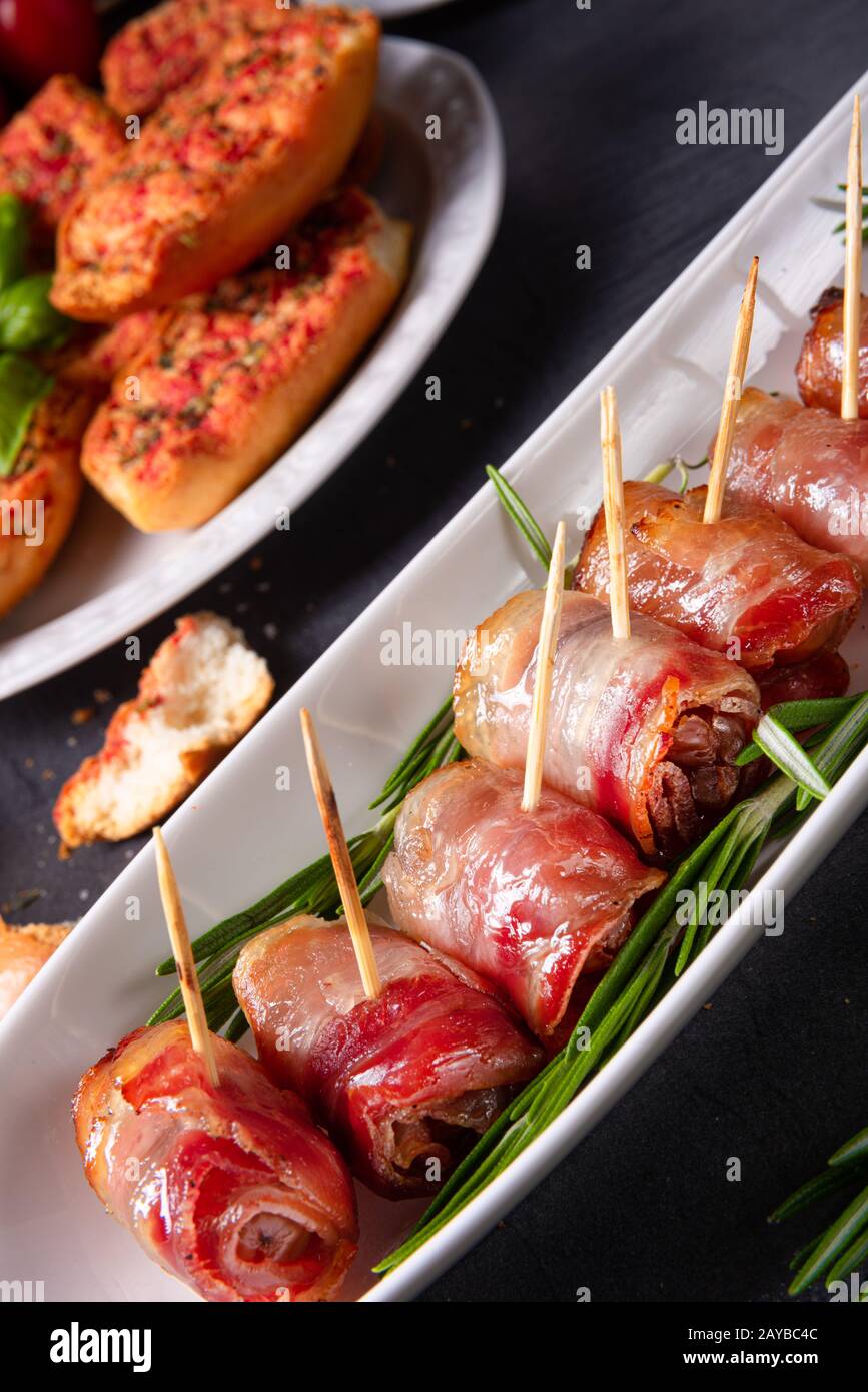 dates wrapped in bacon and delicious tapas Stock Photo - Alamy