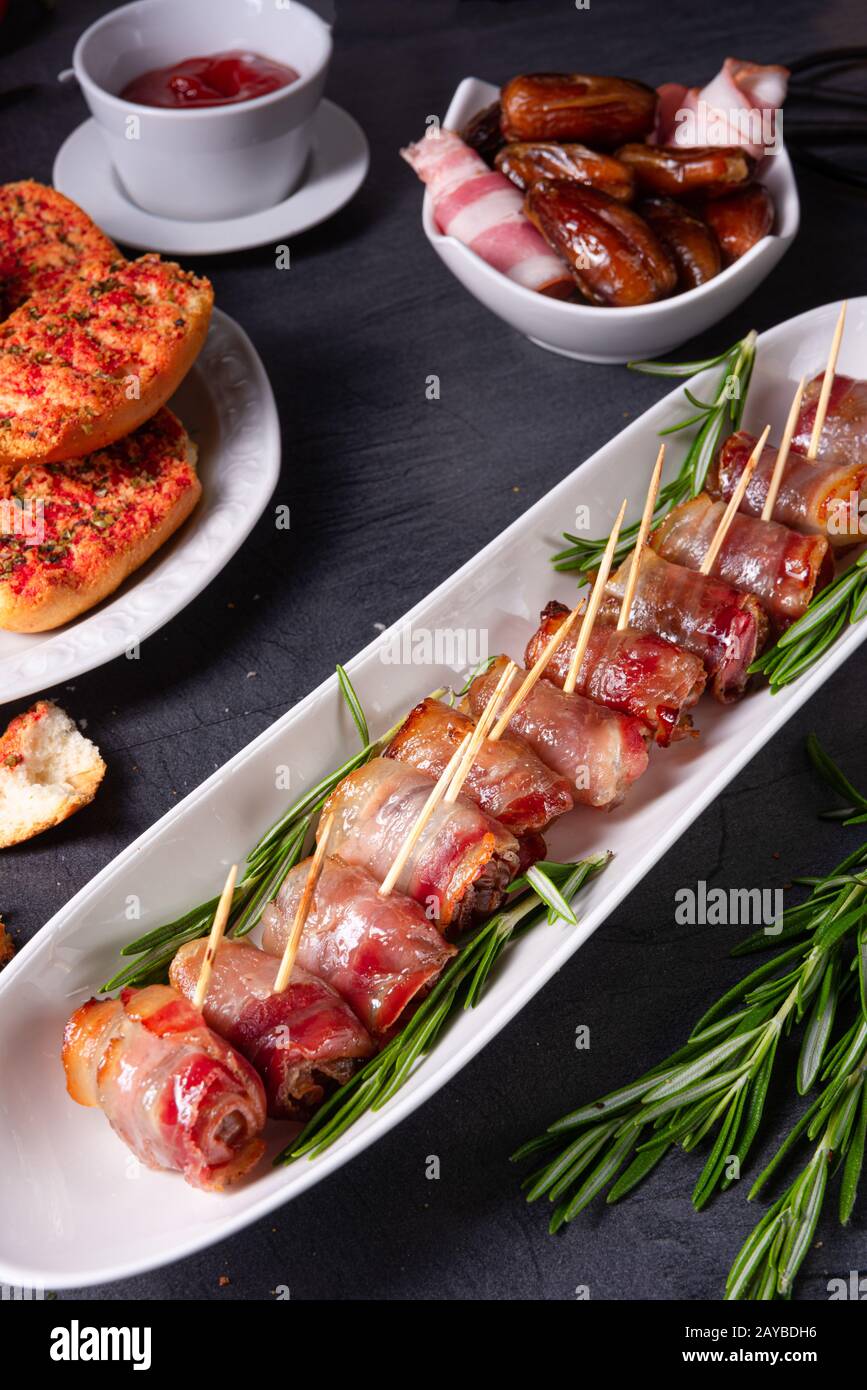 dates wrapped in bacon and delicious tapas Stock Photo - Alamy
