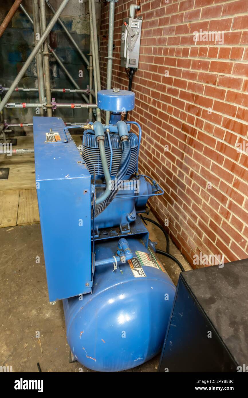 industrial grade air compressor next to masonry brick wall Stock Photo ...