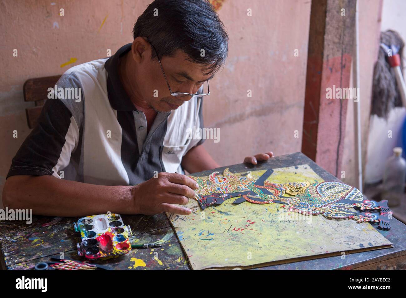 A man is painting traditional Javanese wayang kulit (shadow puppet ...
