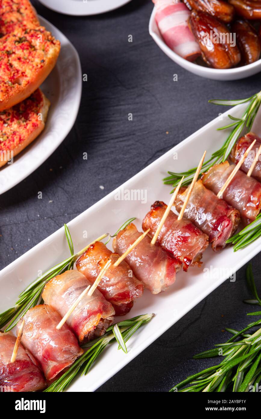 dates wrapped in bacon and delicious tapas Stock Photo - Alamy