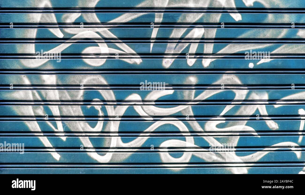 Blue garage gate with graffiti Stock Photo - Alamy
