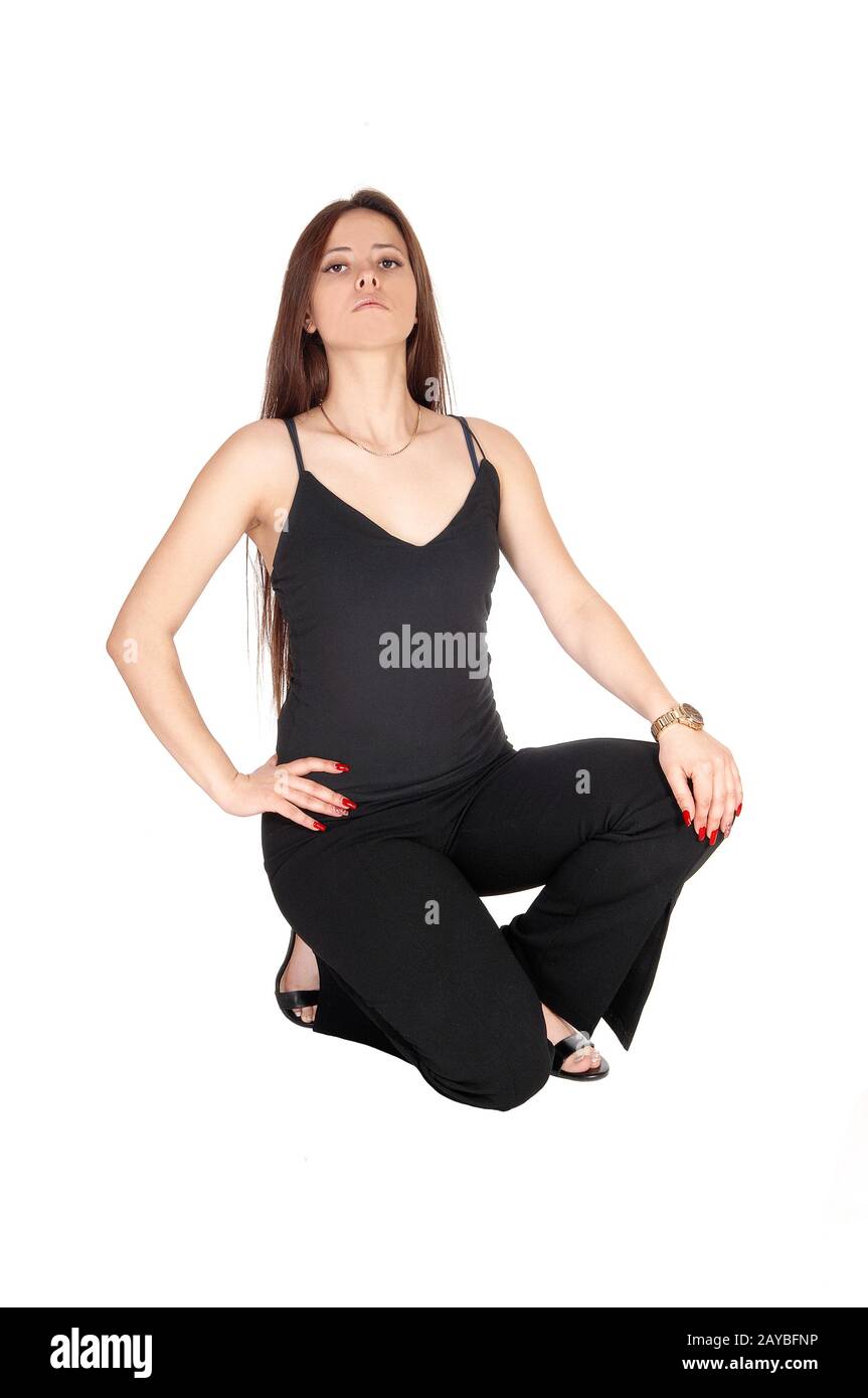 Lovely young woman crouching on the floor in black outfit Stock Photo ...