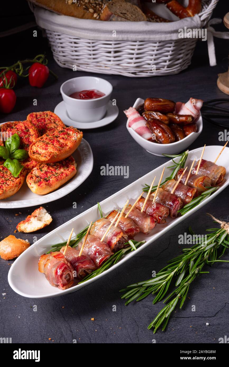 dates wrapped in bacon and delicious tapas Stock Photo - Alamy