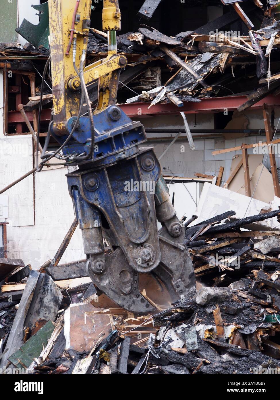 a demolition claw removing debris and rubble from a wrecked building ...