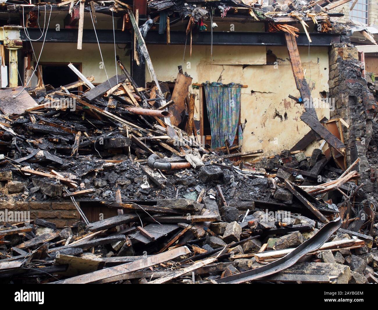 black burned timbers and walls in a collapsed house destroyed by fire ...