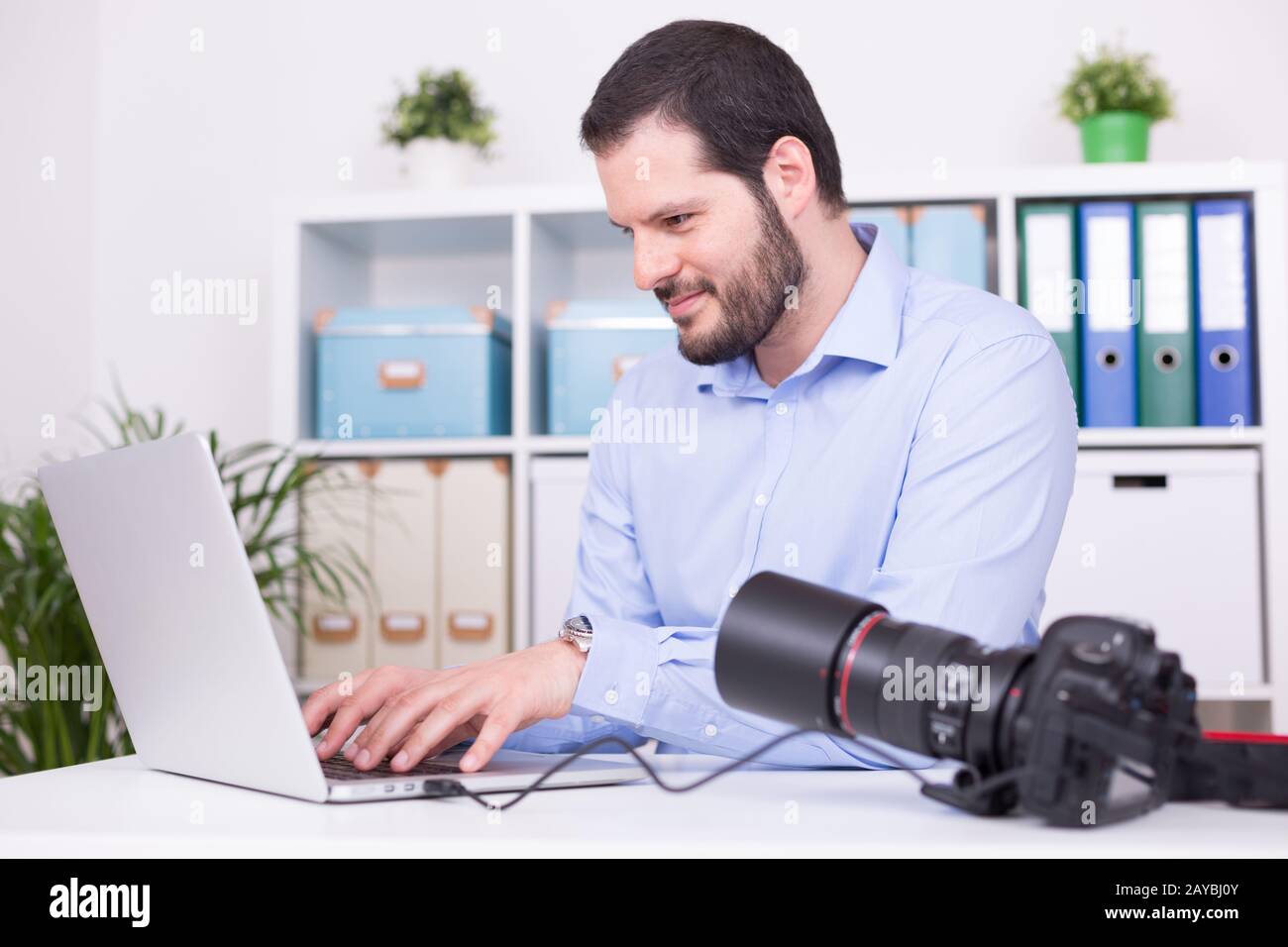 Bearded photographer at his office with laptop and camera Stock Photo ...
