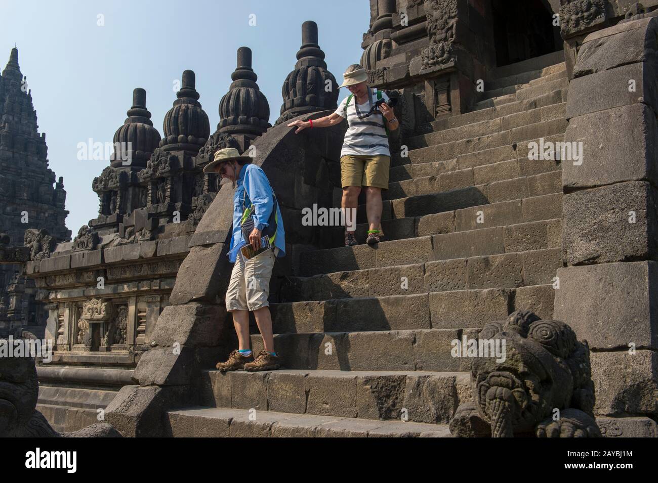 Tourists coming down the steep steps of a temple at the Prambanan ...