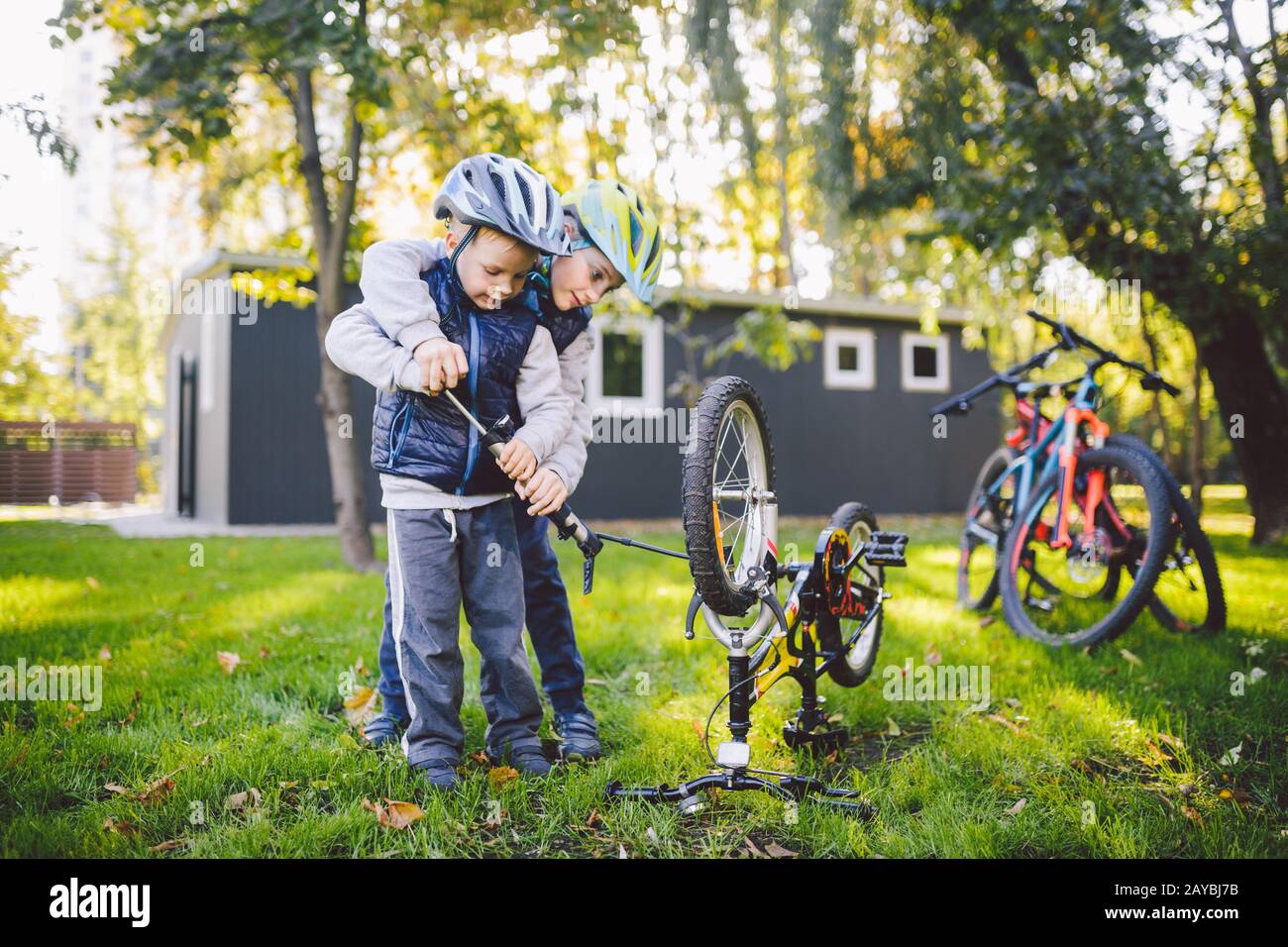 Two children, older boys and younger brother learning repair bike. Two ...