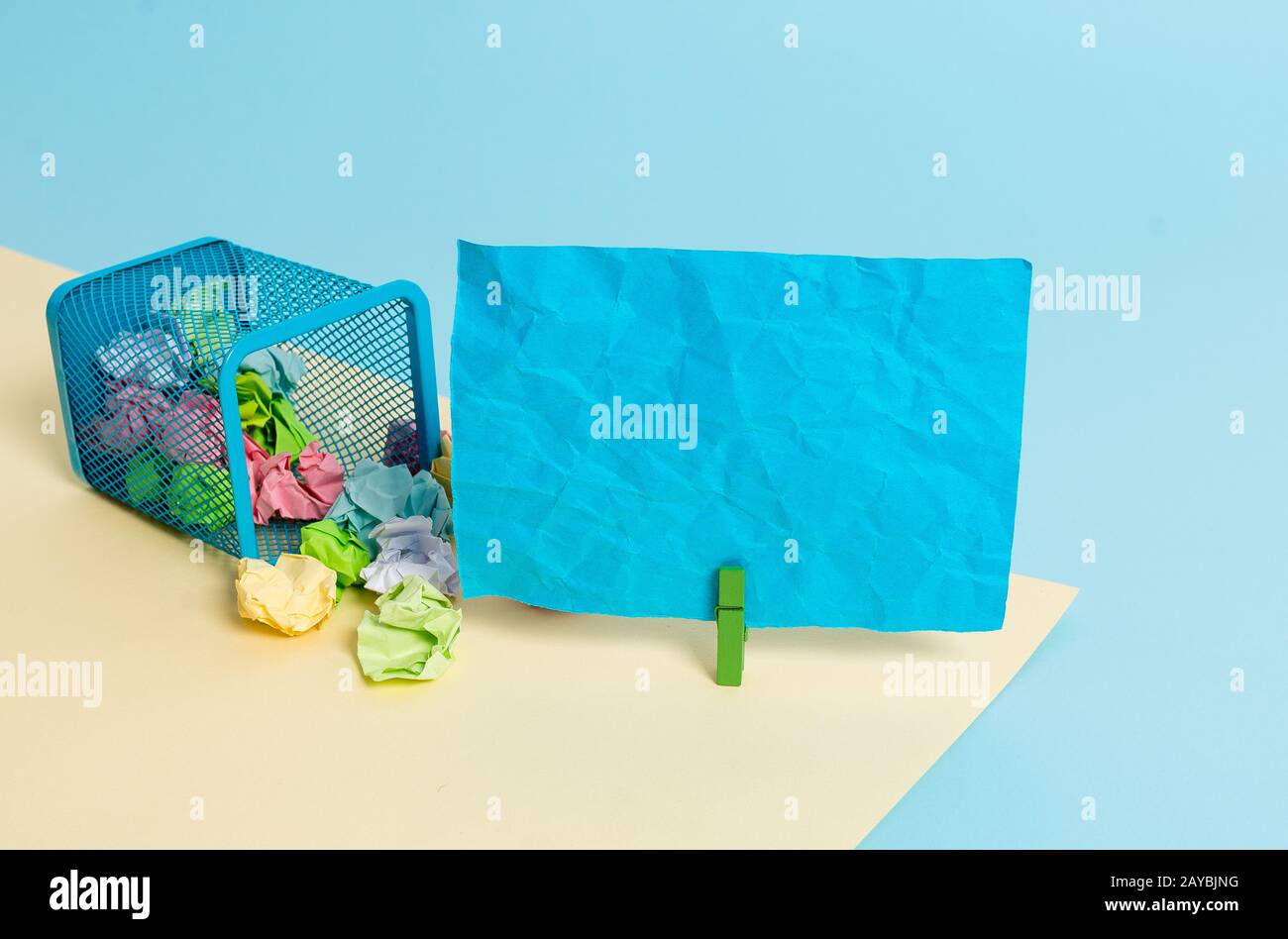 Little tipped trash bin full of crumpled colored paper and a clothespin ...