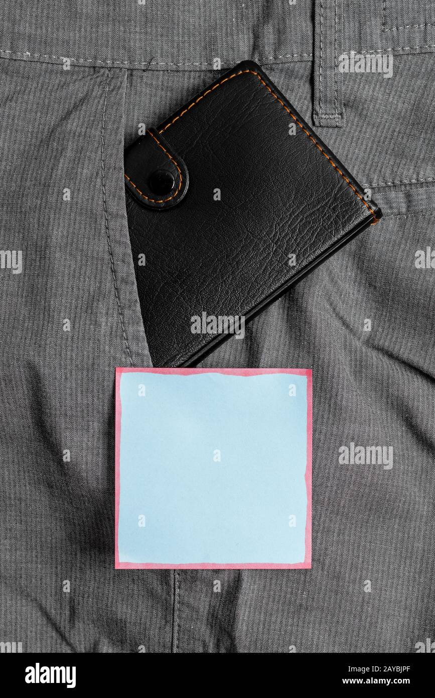 Small wallet in the trousers front pocket beside blue note sheet ...