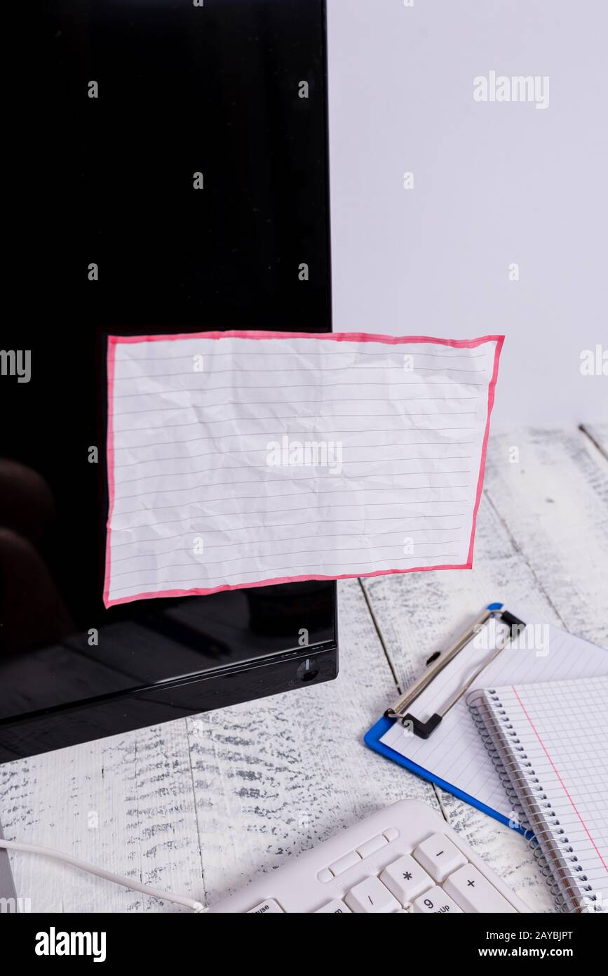 Notation paper stick to black computer screen near white keyboard and ...