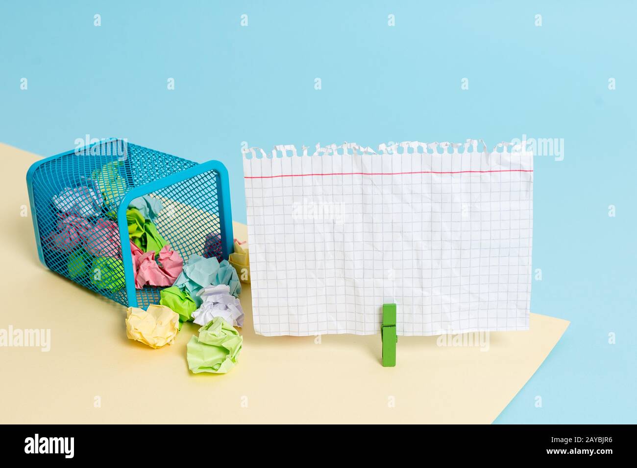 Little tipped trash bin full of crumpled colored paper and a clothespin ...