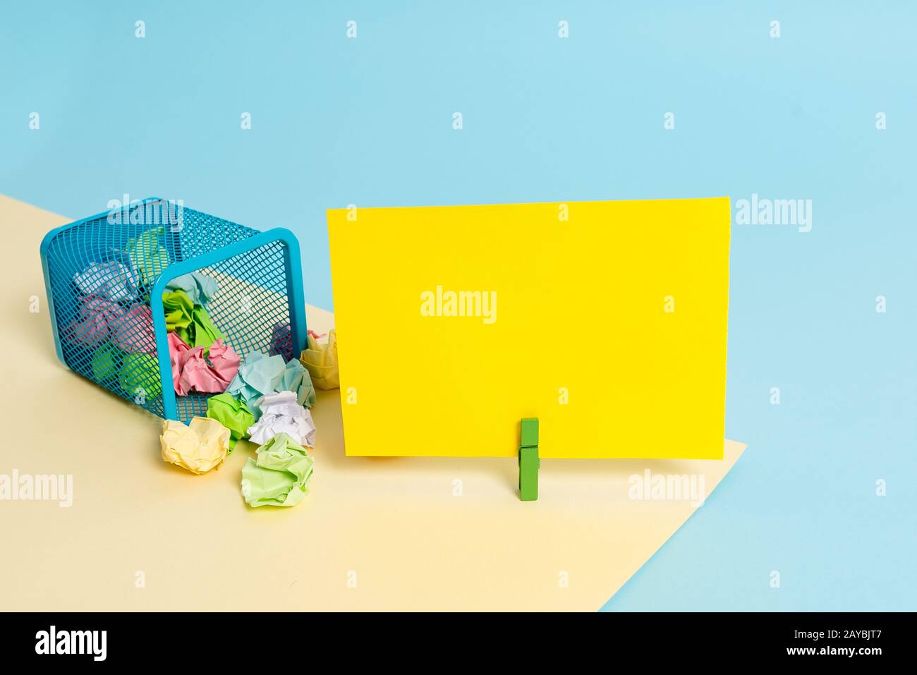 Little tipped trash bin full of crumpled colored paper and a clothespin ...