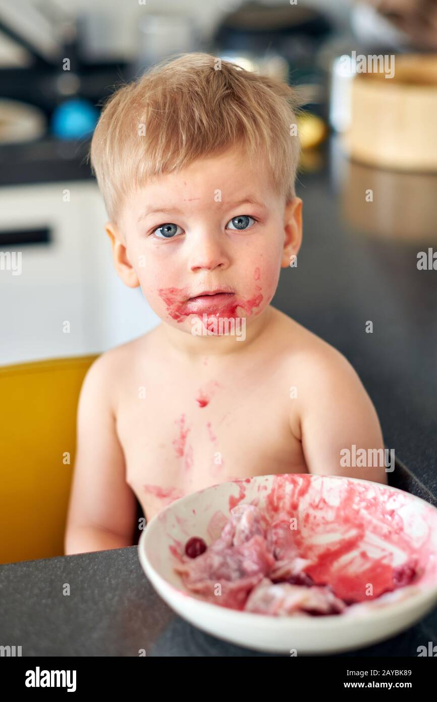 Toddler boy child eating with dirty messy face Stock Photo - Alamy