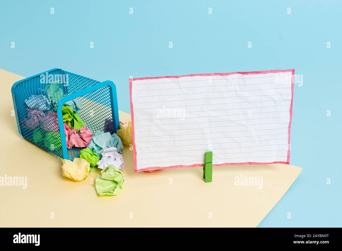 Little tipped trash bin full of crumpled colored paper and a clothespin ...