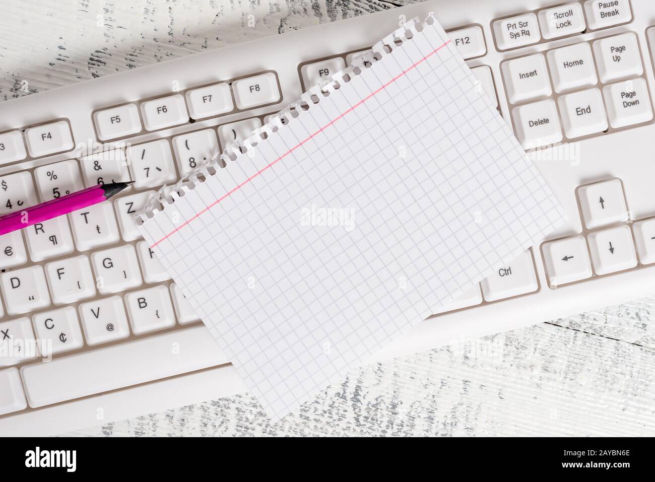 Rectangle shaped note colored paper in a keyboard and a white wooden ...