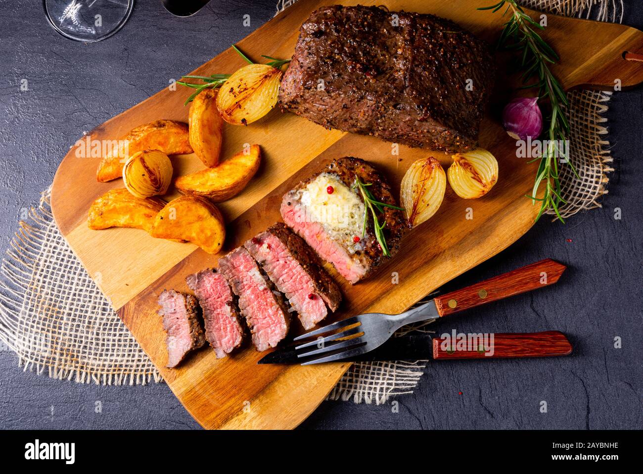 rustic medium butter beef steak with herbs and potato wedges Stock ...
