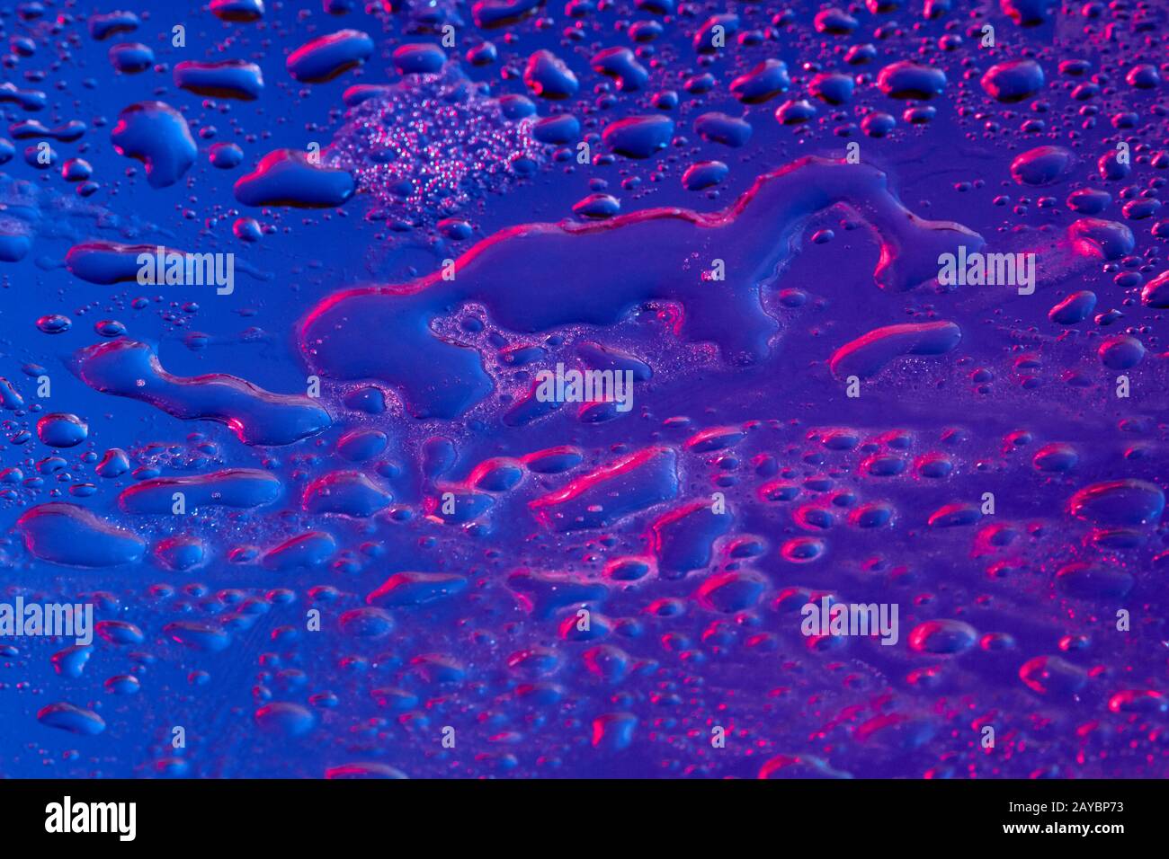 Neon lighted water droplets on a blue surface Stock Photo - Alamy
