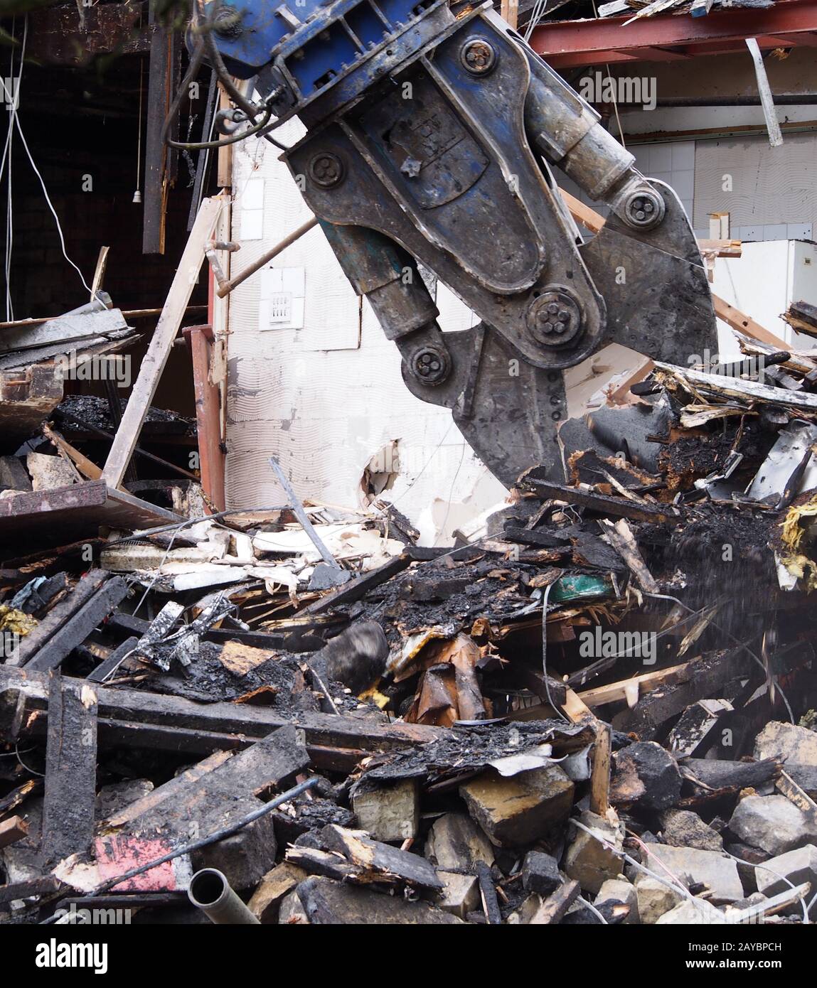 close up of a demolition claw working picking up debris in the wreckage ...