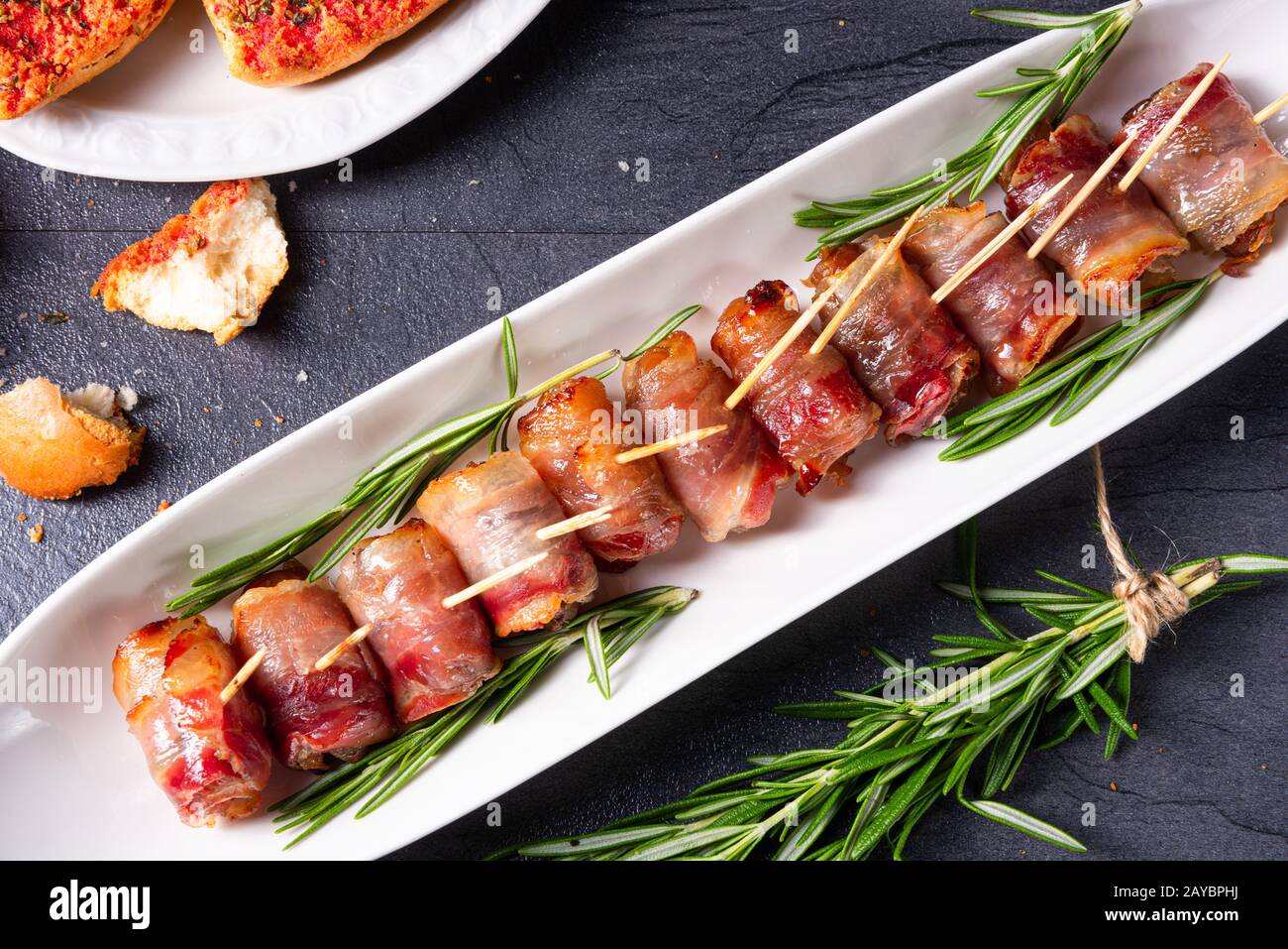 dates wrapped in bacon and delicious tapas Stock Photo - Alamy