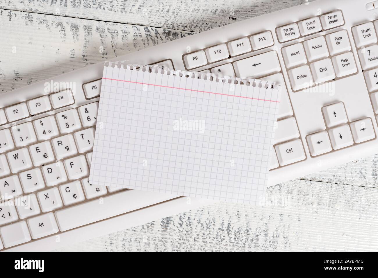Rectangle shaped note colored paper in a keyboard and a white wooden ...