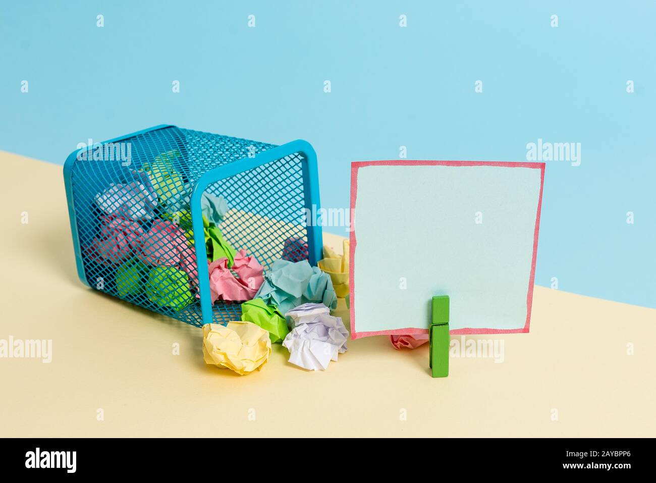 Little tipped trash bin full of crumpled colored paper and a clothespin ...