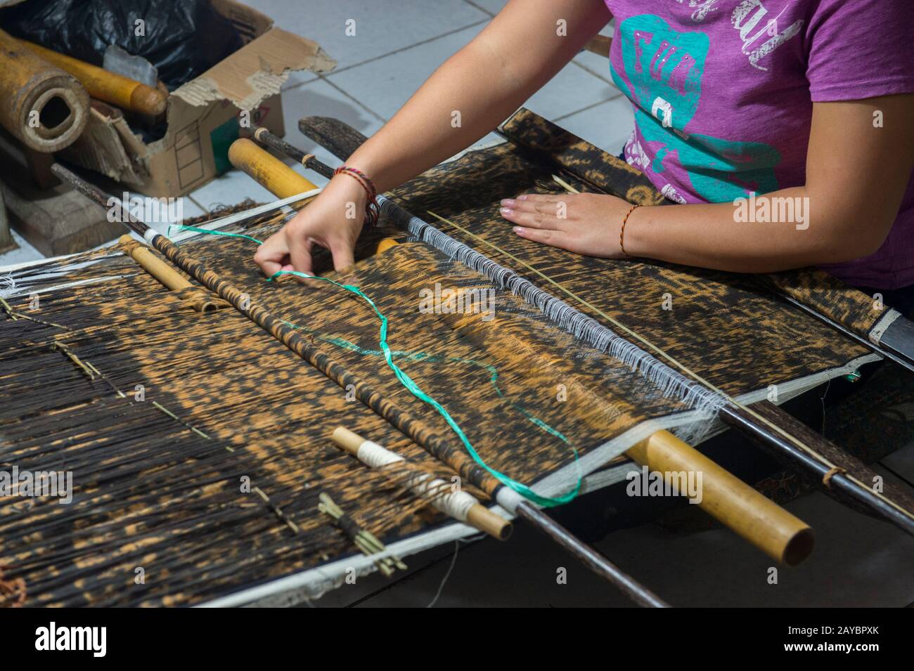 A woman is weaving double Ikat in her house in the Tenganan Village in ...