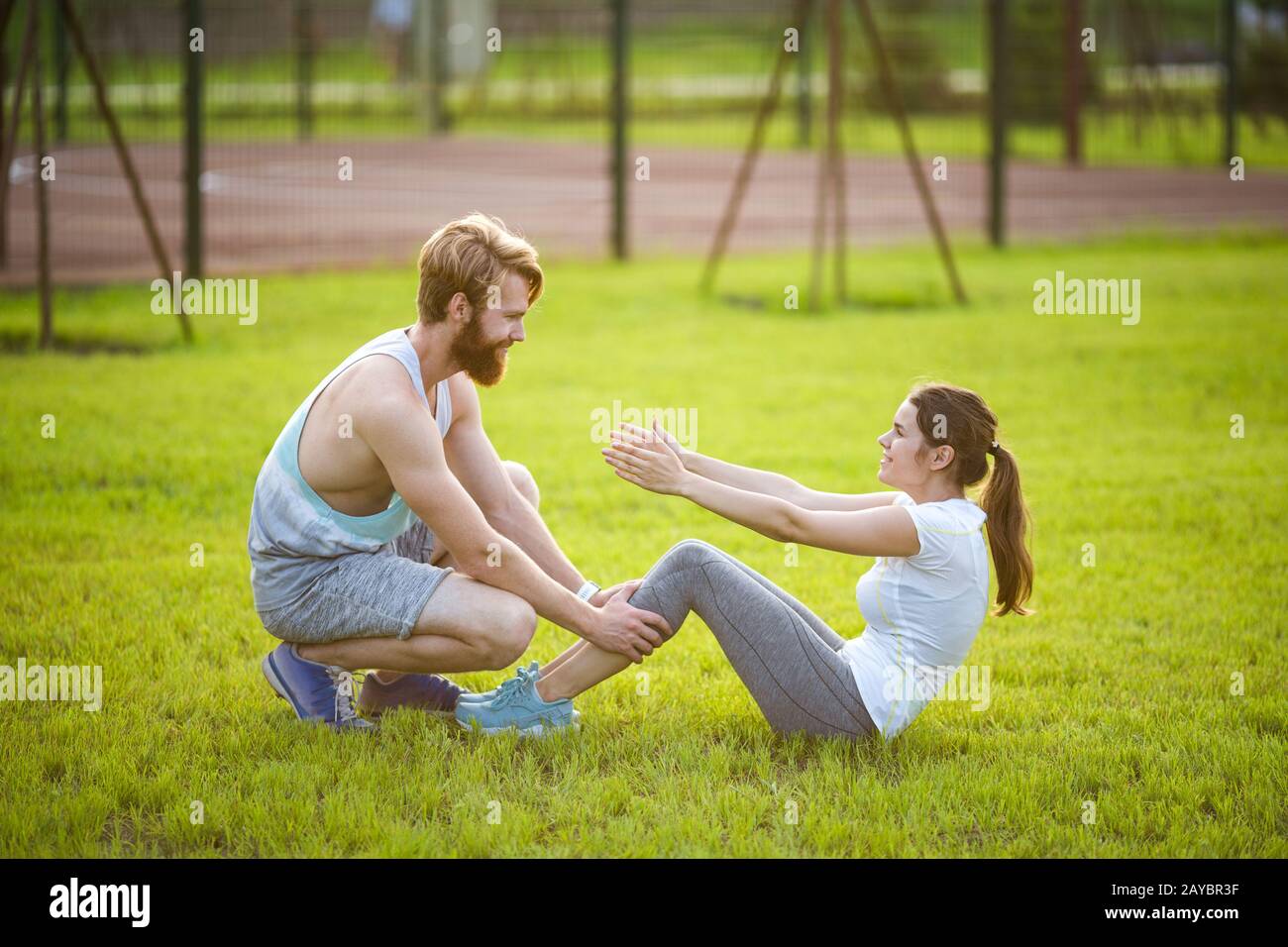 Sit ups fitness couple exercising sit up outside in grass. Fit people ...