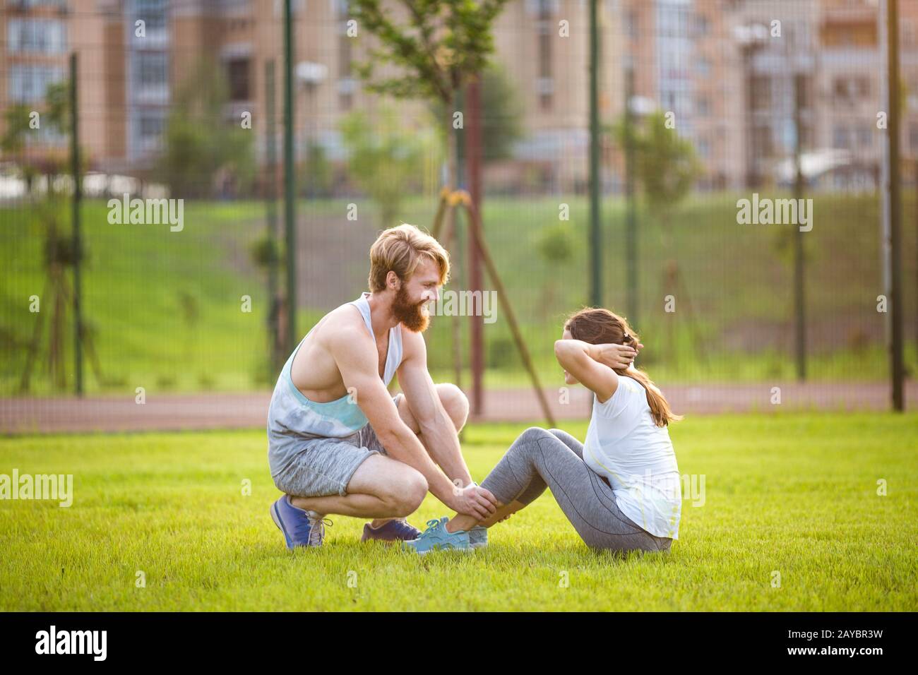 Sit ups fitness couple exercising sit up outside in grass. Fit people ...